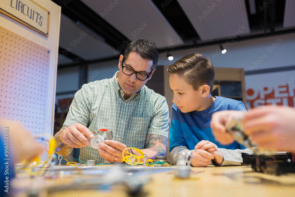 Teacher and student assembling electronic circuit science center Stock ...