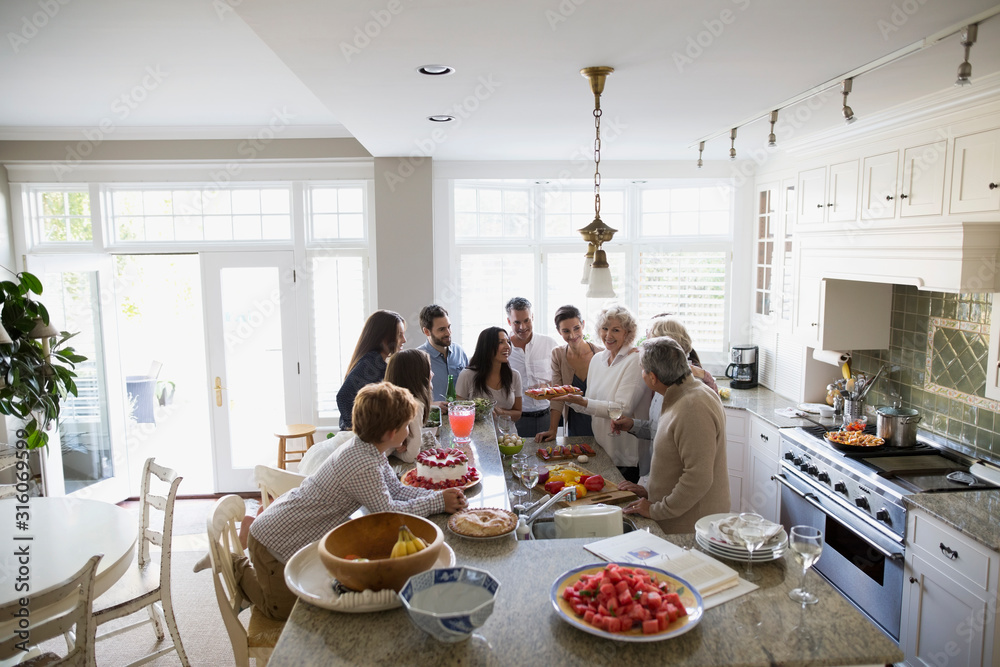 Multi-generation family gathering around kitchen island Stock Photo ...