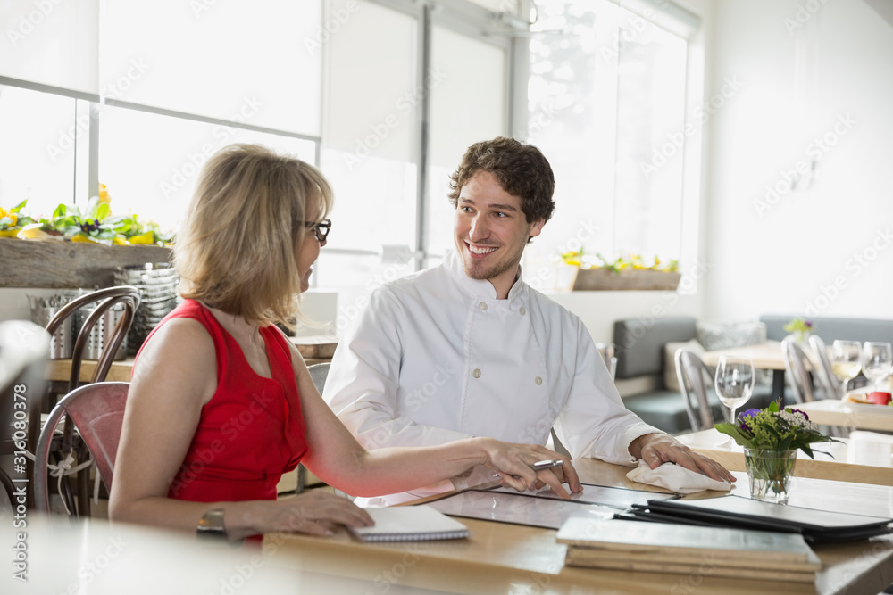 Bistro owner and chef planning menu at table Stock Photo | Adobe Stock