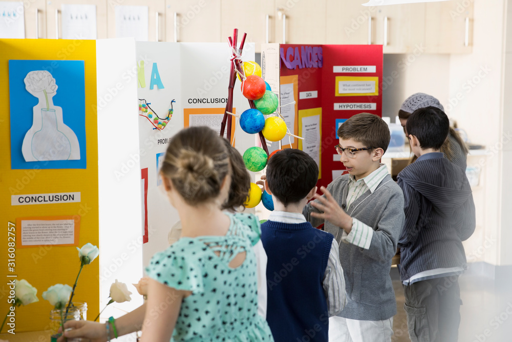 School boy explaining science fair project to classmates Stock Photo ...