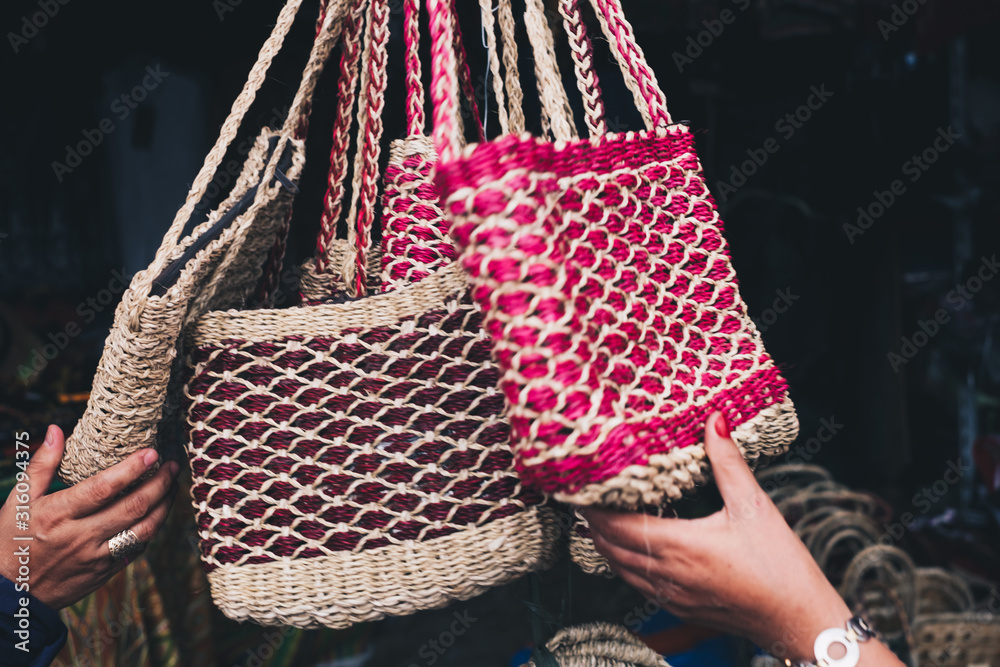 Womens' hands selecting handmade Abaca bags or purses, made from the ...