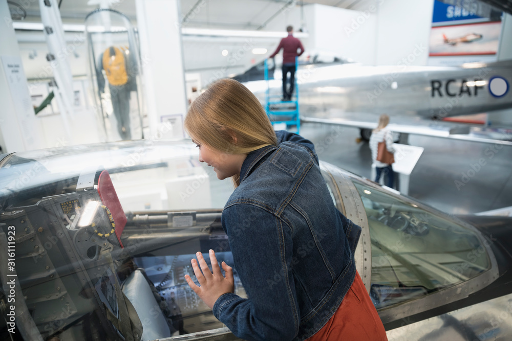 Curious girl looking inside airplane cockpit in war museum hangar Stock ...