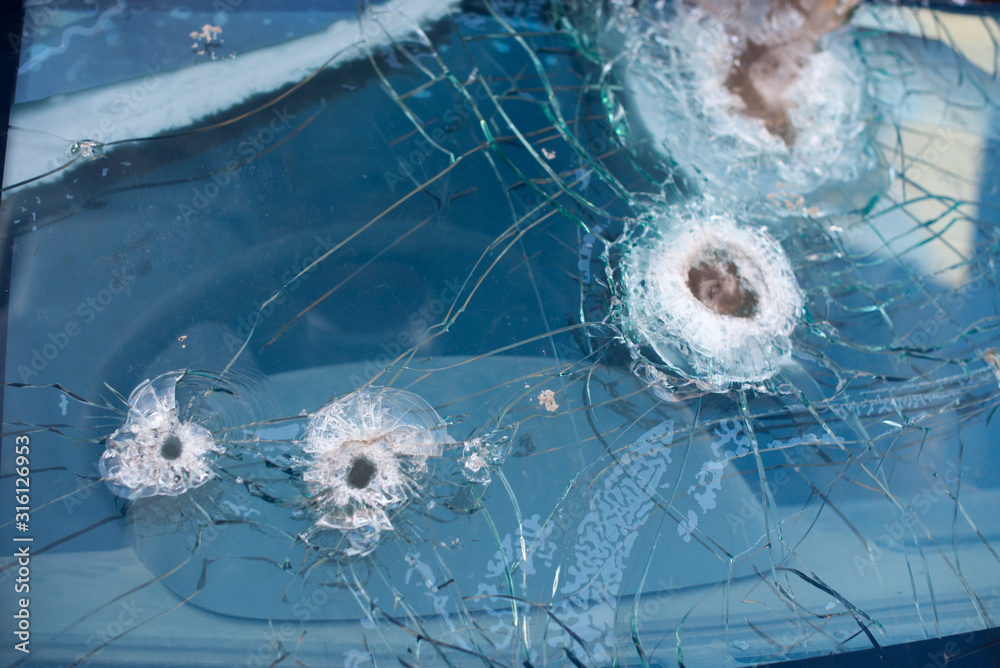 Bullet hole on a car windshield. Car window after a raid has a bullet ...