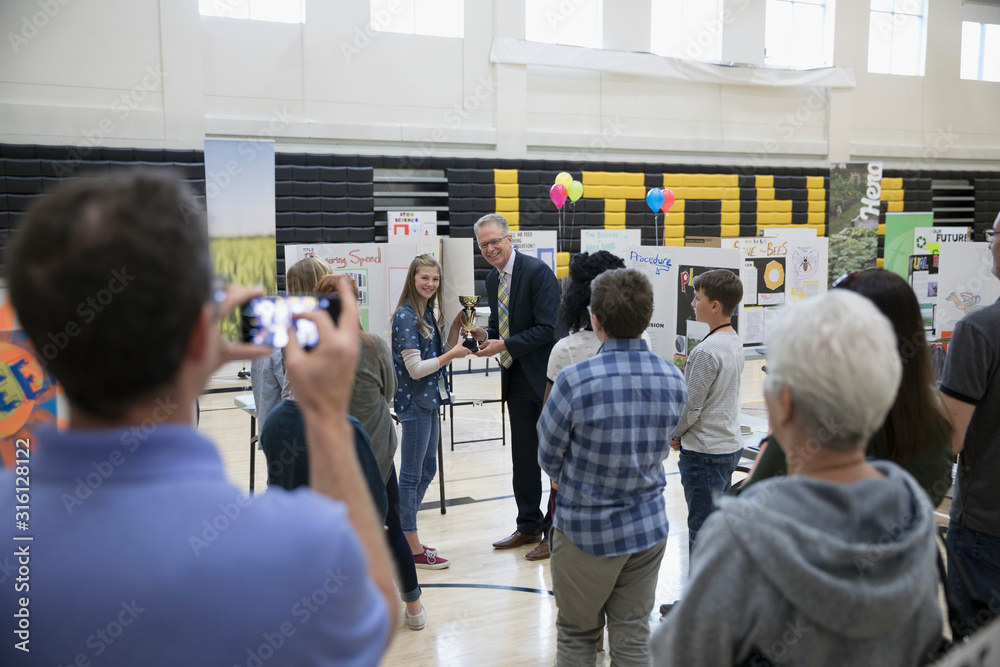 Science teacher awarding middle school student at science fair Stock ...