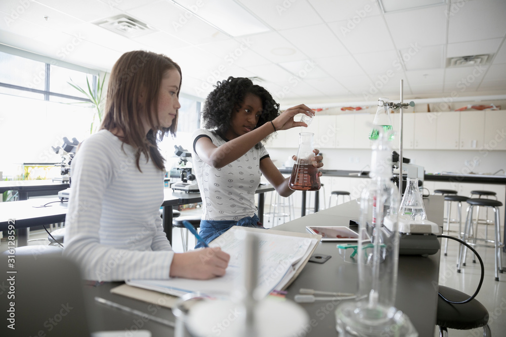 Girl middle school students conducting scientific experiment in science ...