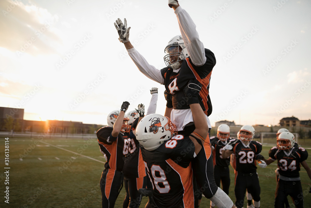 Teenage boy high school football players lifting celebrating, cheering ...