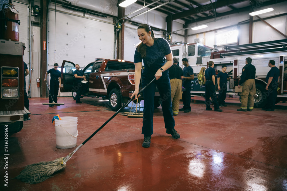 Female firefighter mopping fire station floor Stock Photo | Adobe Stock