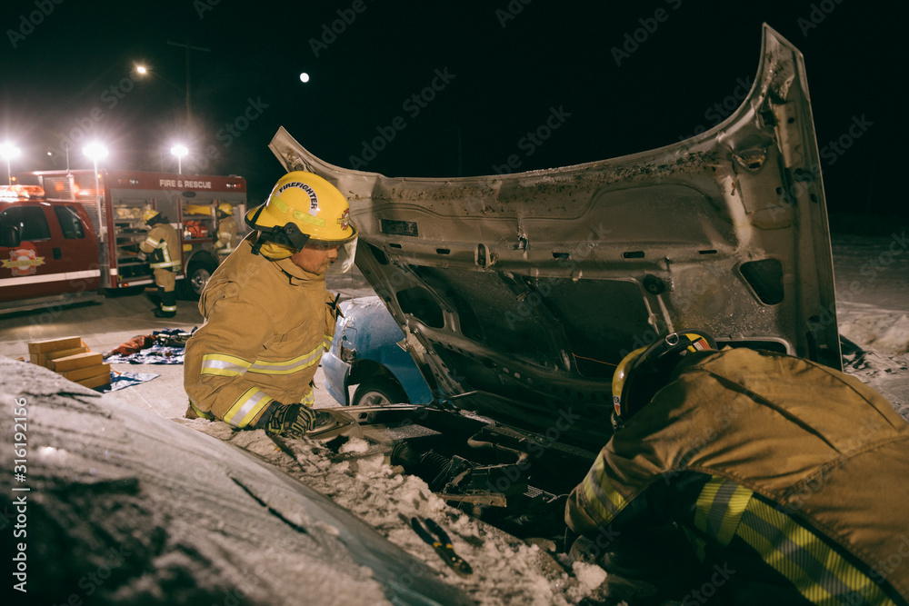 Firefighters extinguishing car fire at scene of car accident Stock ...
