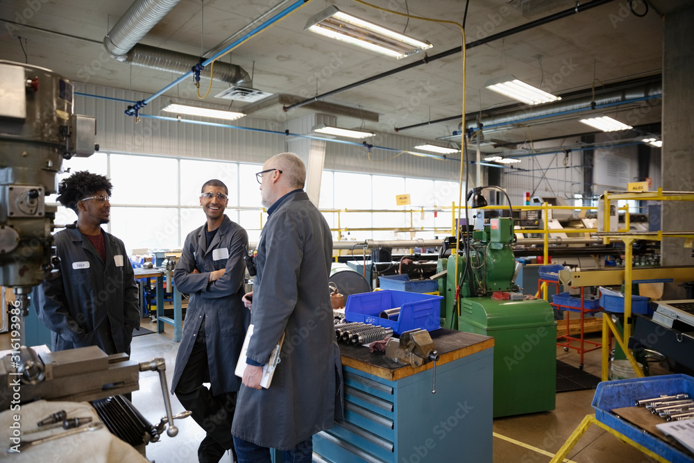 Machinists talking in factory Stock Photo | Adobe Stock