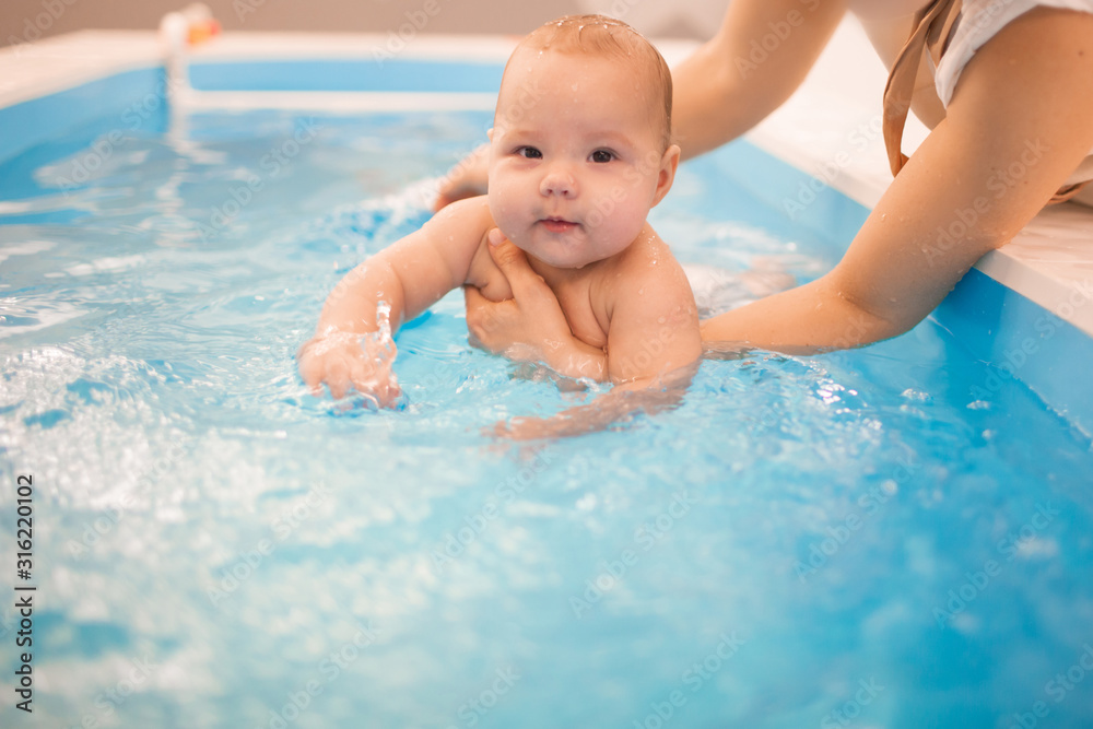 Litle baby in pool swimming bathing during health procedures. Stock ...