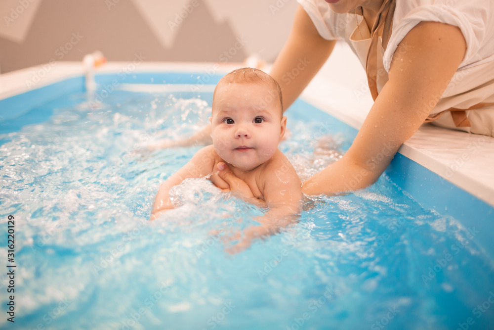 Litle baby in pool swimming bathing during health procedures. Stock ...