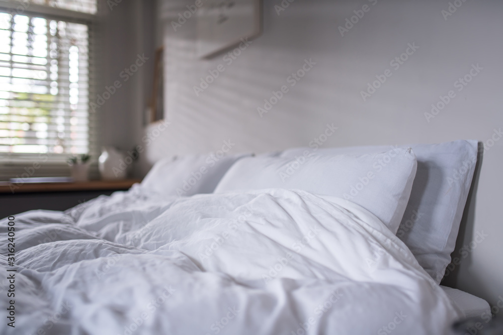 Side view of a white wall bedroom interior with a double bed, a bedside ...