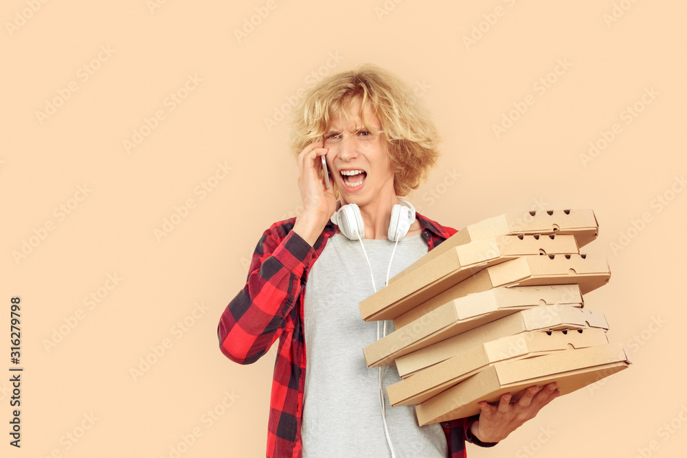 Freestyle. Teen blond delivery boy in headphones standing isolated on ...