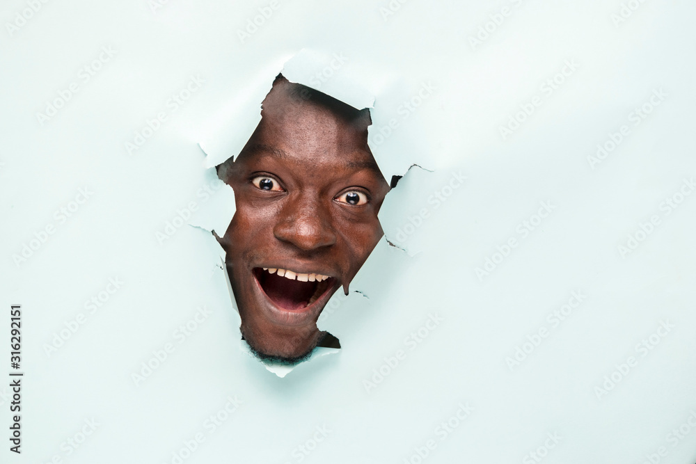 handsome young black man with head through a cardboard paper feeling ...