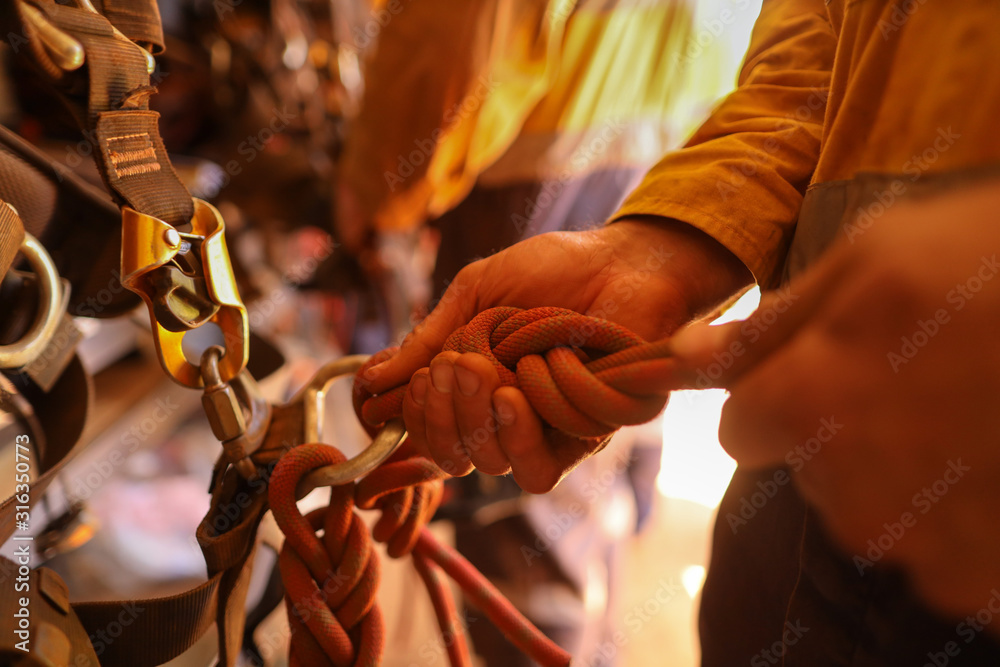 Rope access technicians double checking inspecting gear figure of eight ...