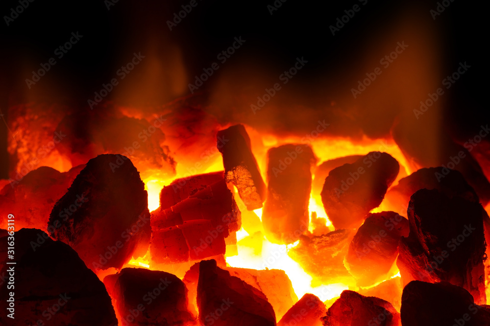 Red hot coal bars in focus on dark background with flames. Background ...