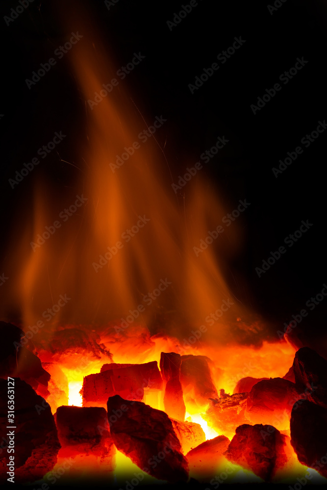 Red hot coal bars in focus on dark background with flames. Background ...