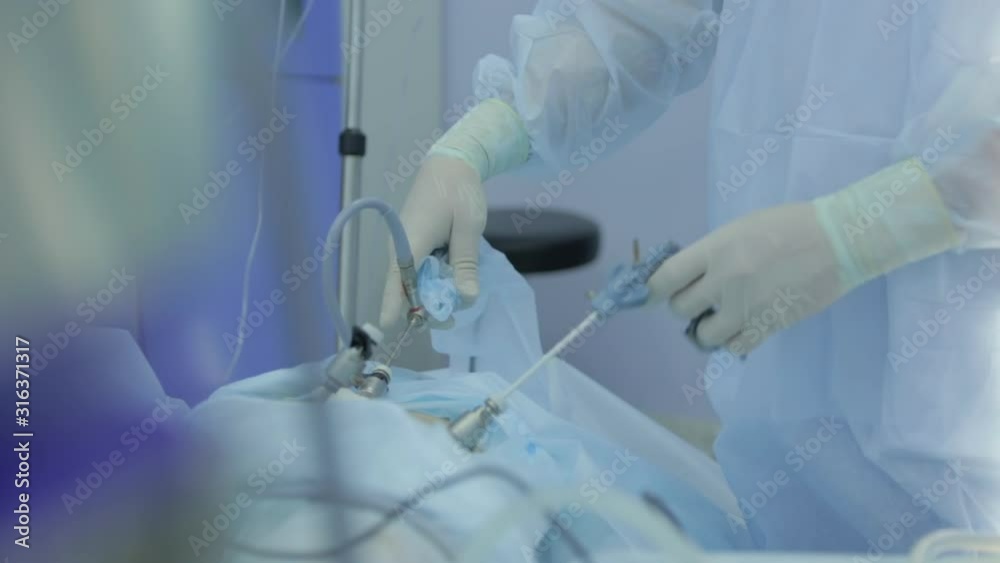 Surgeon in modern operating room operates on patient using minimally ...