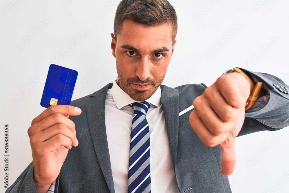 Young handsome business man holding credit card over isolated ...