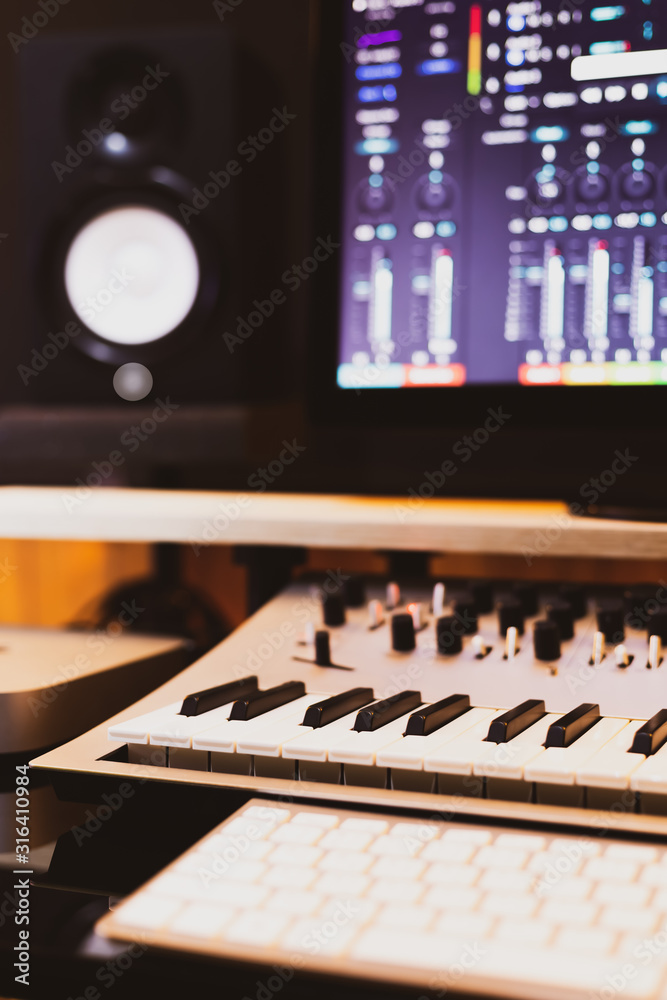keyboard synthesizer, computer and monitor loudspeakers on desk. music ...