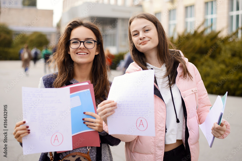 Grade / test results. Female students showing papers with perfect test ...
