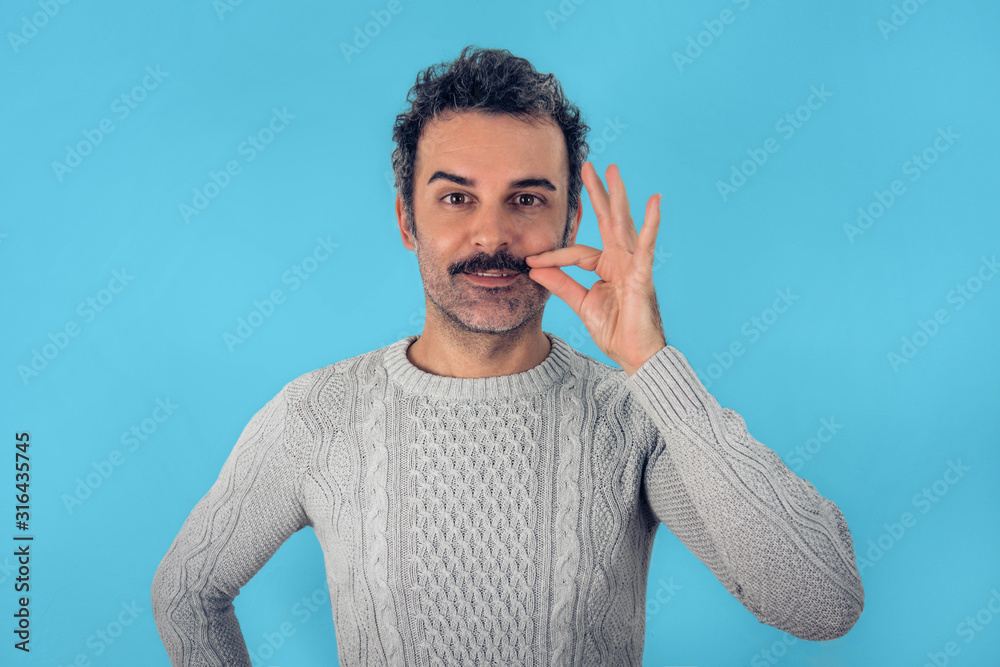 Funny portrait of brown, smiling, handsome man touching his mustache ...
