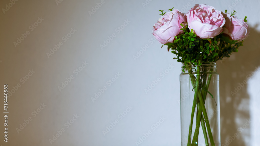 Ramo de flores artificiales en un florero de vidrio. Luz directa blanca ...