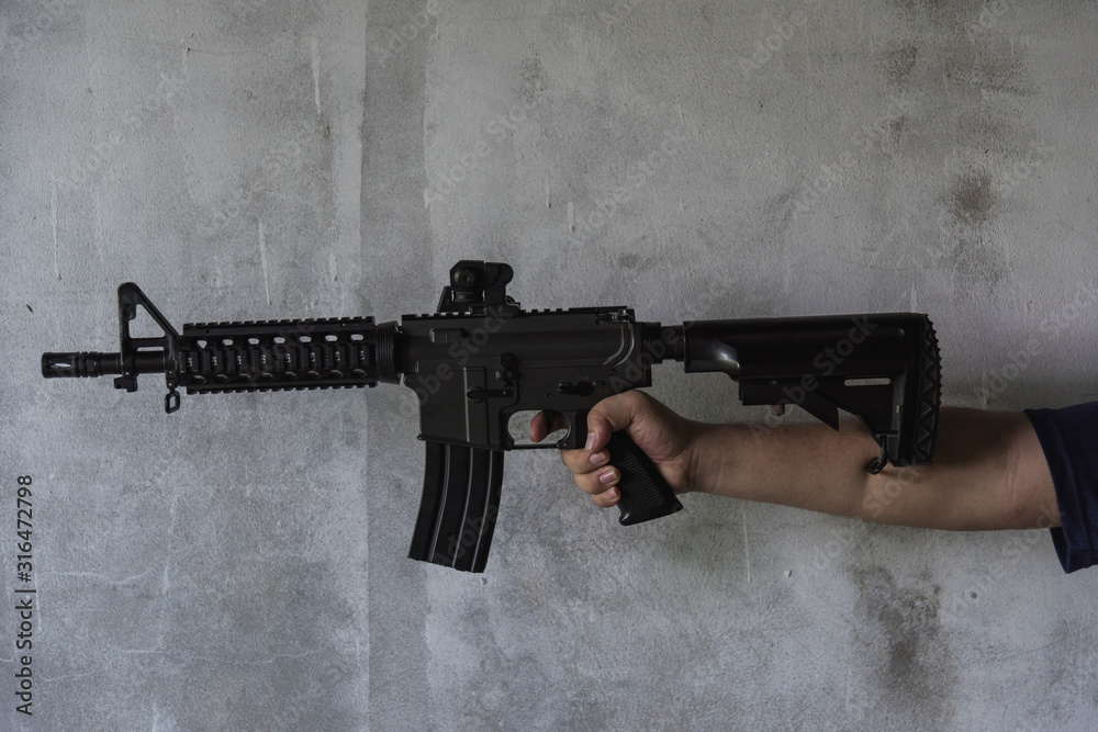 Hand holding M16 gun Stock Photo | Adobe Stock