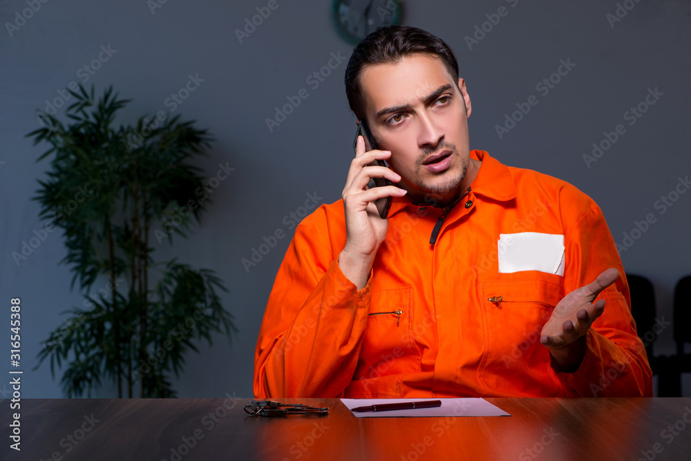 Young convict man sitting in dark room Stock Photo | Adobe Stock