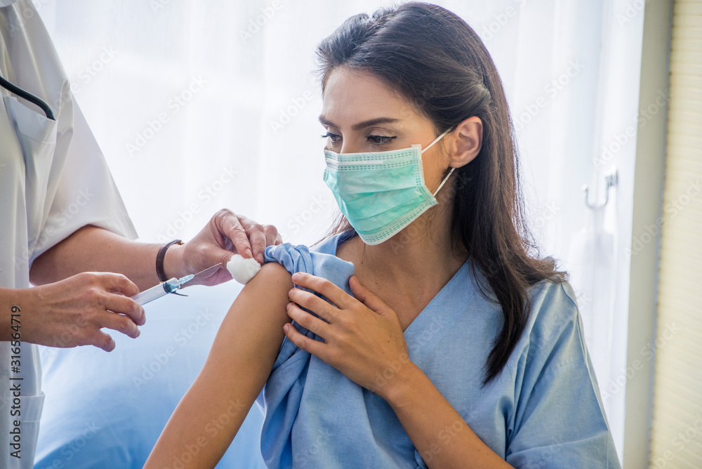 The female doctor with syringe to injection to the young patient put on ...