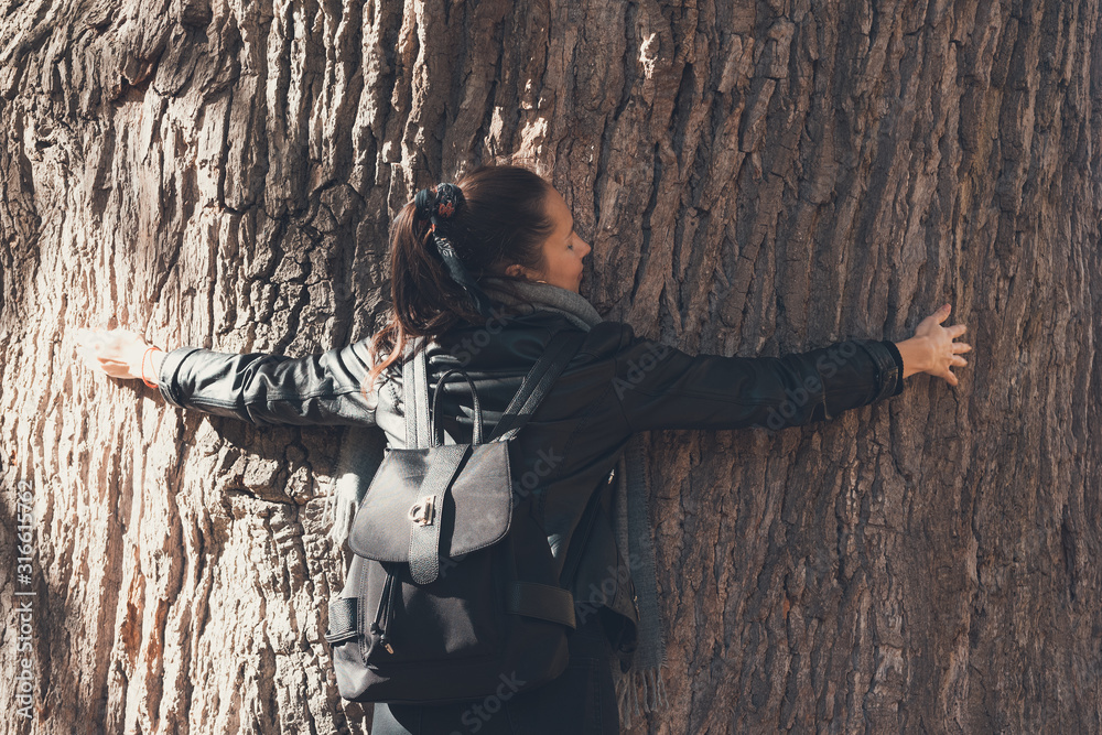 Girl hugging a huge tree. The power of trees. Protection of nature ...