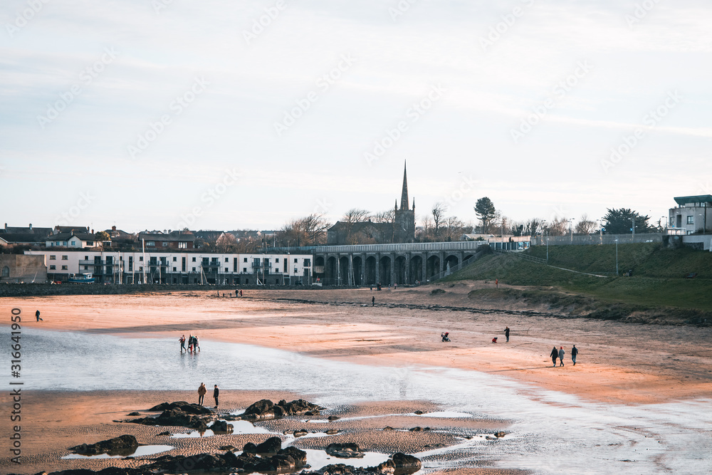 Poster People Walking Around The Balbriggan Beach. – Wall Art | UkPosters