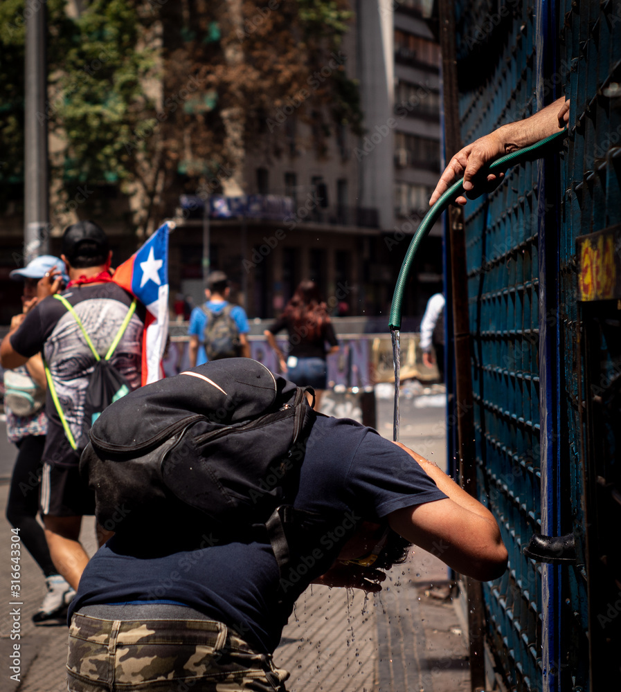 man throwing water through a hose to a person in the street during a ...