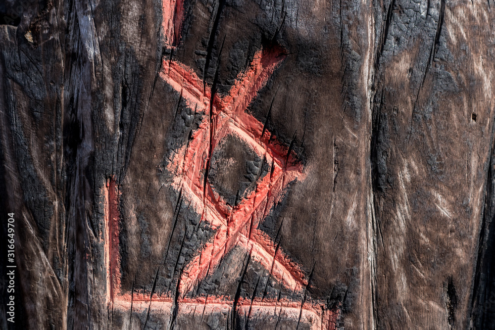 Slavic pagan esoteric symbols (runes) are carved on a wooden surface ...