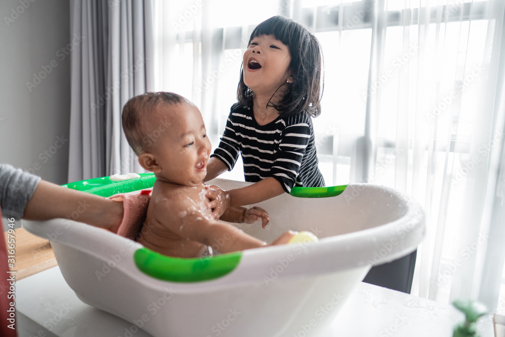 cute asian little sister help her baby brother to bath Stock Photo ...