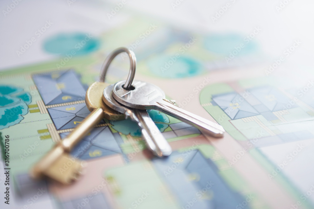 Key ring with three keys lying on architectural blueprint close-up ...