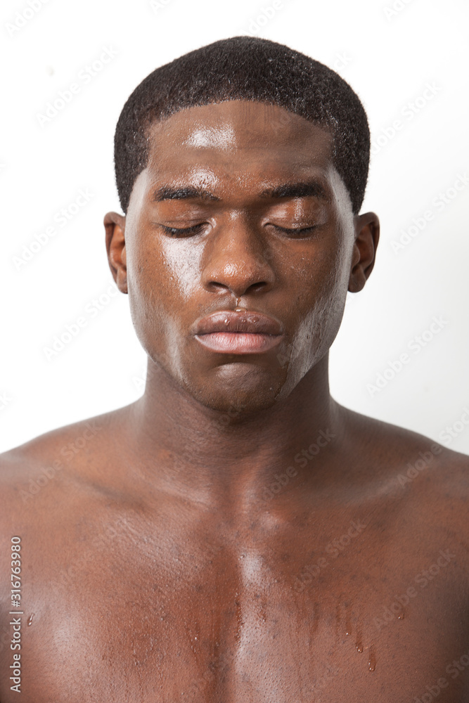Shirtless young African American man sweating over white background ...