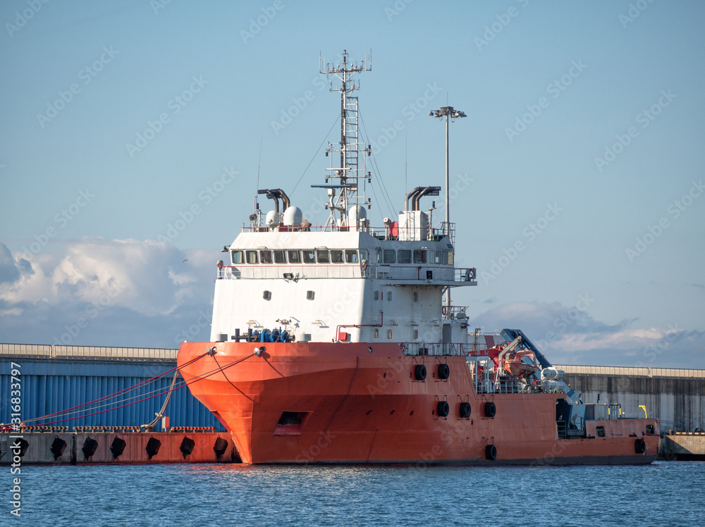 Platform supply vessel anchored in sea port at sunny day. Front view of ...