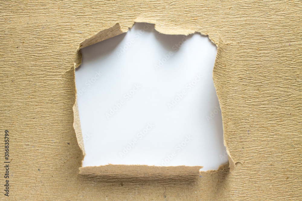 Frame made of textured old gray paper with a torn hole in the middle ...