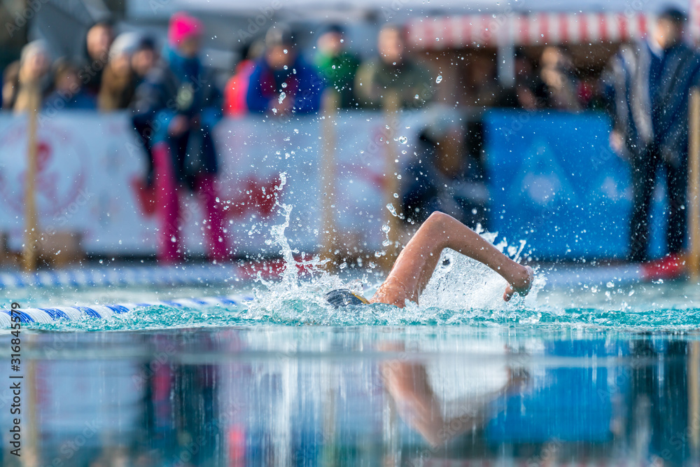 Woman swimming in an outdoor pool at an ice swim competition Stock ...