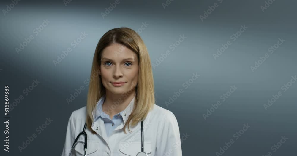 Rear of the Caucasian blond young attractive female doctor in the white ...