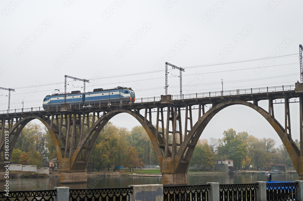 Locomotive moves along railroad arch bridge Stock Photo | Adobe Stock