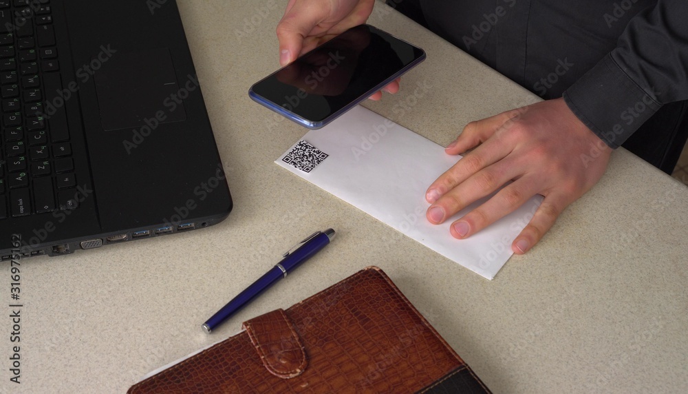 QR Code an envelope. A man scans Qr code label for tracking a delivery ...