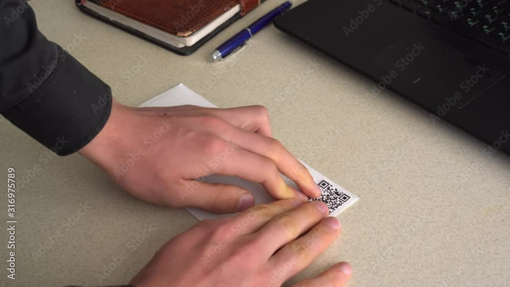Shipping Label For Delivery. A man sticks on an envelope a QR Code with ...