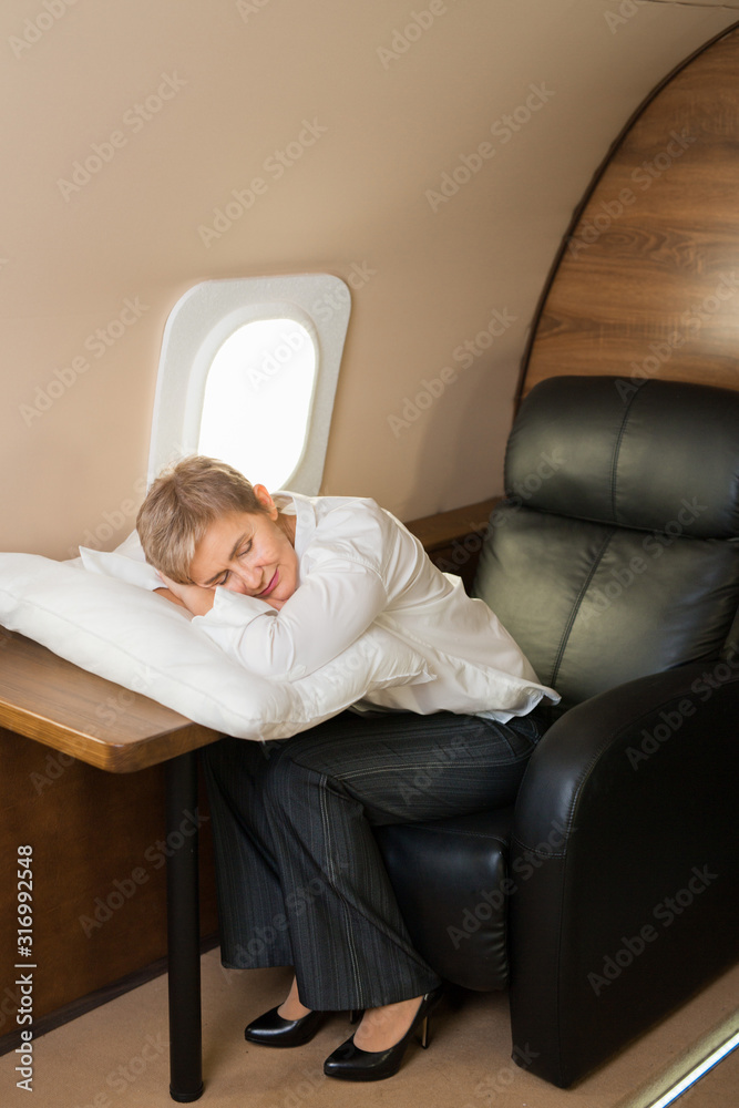 beautiful stylish woman aged sleeping in a private jet cabin on a ...
