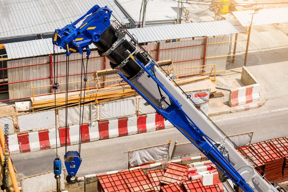 Blue crane boom with hooks and sling cable at construction site. Boom ...