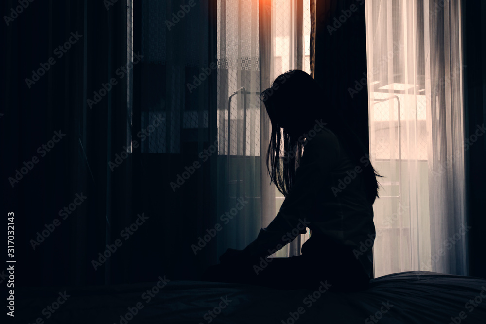 Sad young woman sitting on the bed in the bedroom, People with ...