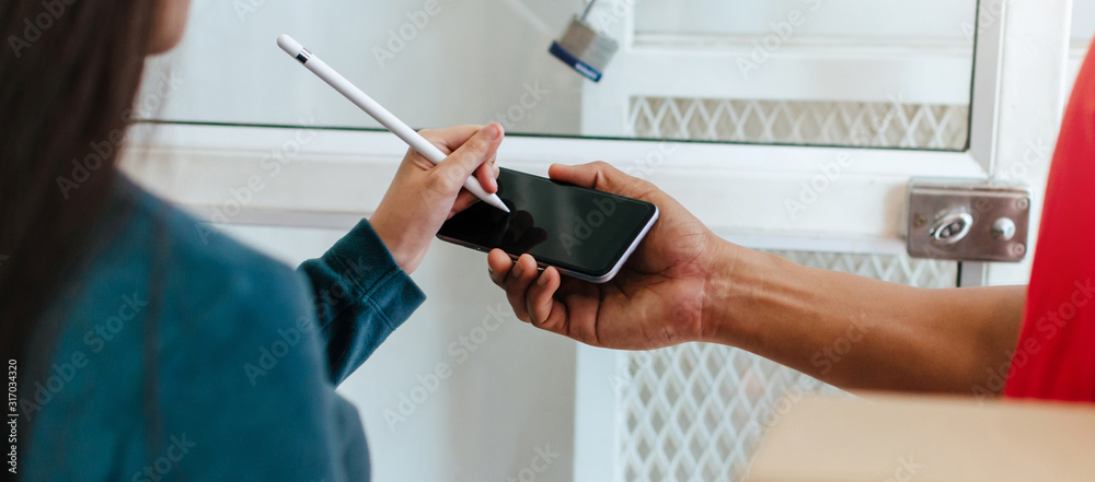 panoramic banner. woman customer using pen signature on digital mobile ...