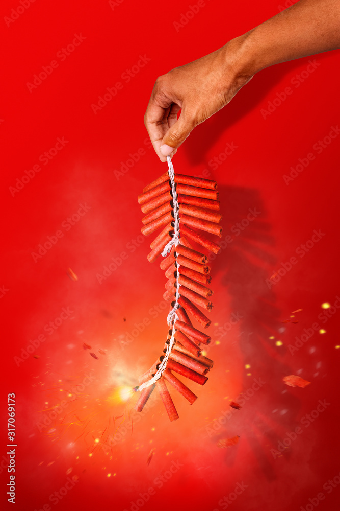 Hand holding lighten up Fire cracker Stock Photo | Adobe Stock