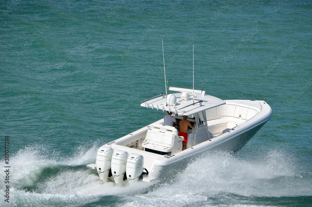 Open sport fishing boat powered by three outboard engines Stock Photo ...
